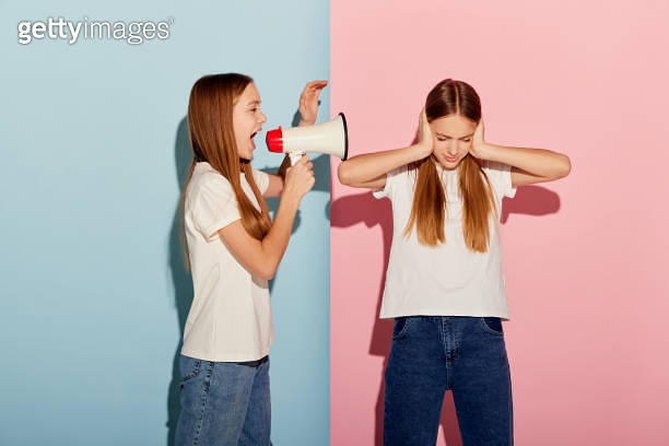 Young teen girl shouting at megaphone at her friend or sister isolated ...