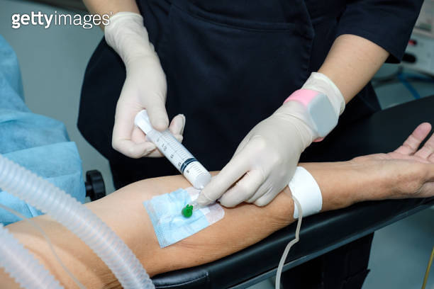 Injecting anesthesia through a catheter on the patient's arm ...