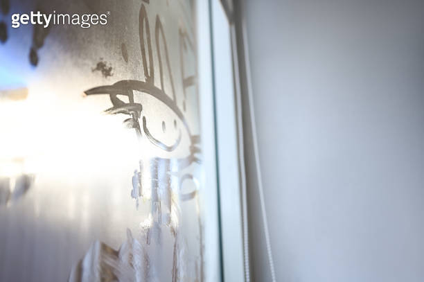 Children's drawing on a wet window. Condensation on the window ...