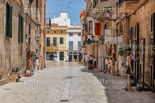 People walking in a street lined with shops and boutiques in the center ...