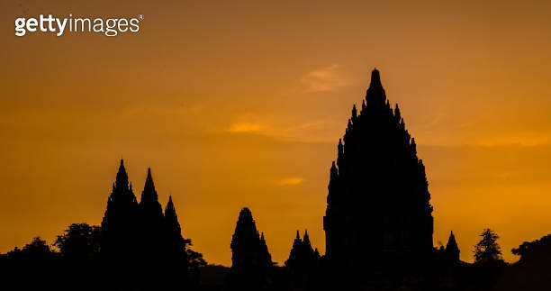 Sunset over the ancient temple ruins of Prambanan (Candi Prambanan) a ...