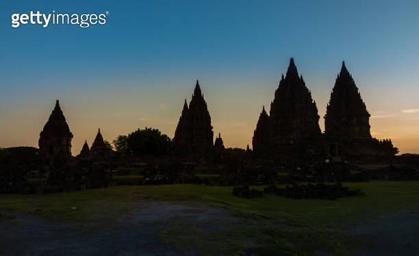 Sunset over the ancient temple ruins of Prambanan (Candi Prambanan) a ...