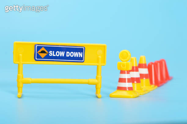 yellow and red safety cones with text SLOW DOWN. Reduce speed road sign ...
