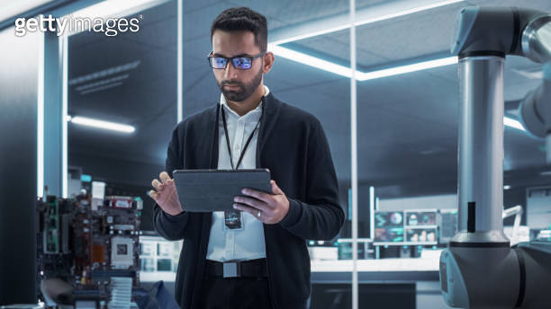 Industrial Robotics Professional Interacting with Robotic Arm During a ...