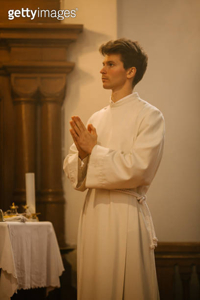 Portrait of a Male Young Minister in White Robes Standing Humbly During ...