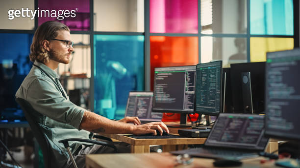 Professional Male Programmer Writing Code on Desktop Computer With ...