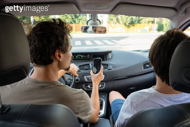 Man using phone while driving a car 이미지 (1657434183) - 게티이미지뱅크