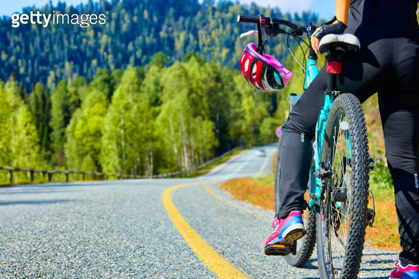 Girl on mountain bike stopped on side road near, helmet whistle on ...