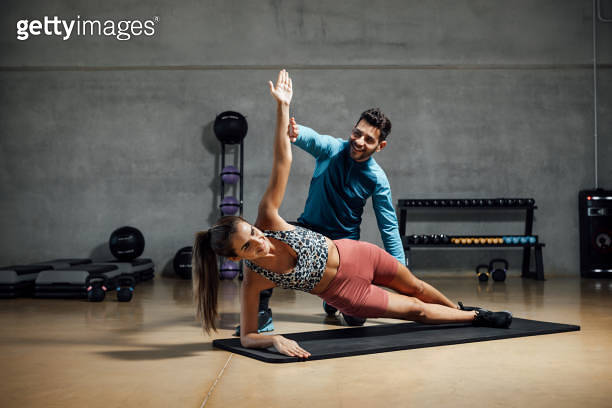 Trainer showing right position to do abs in a gym hiit class. 이미지 ...