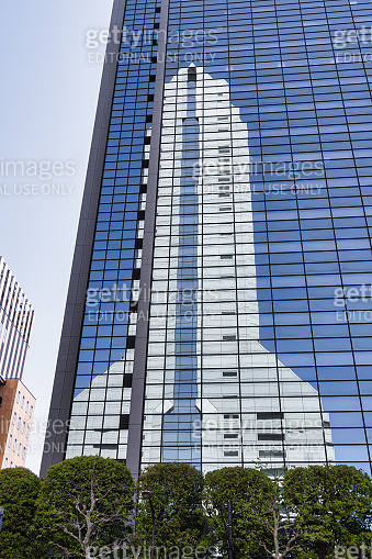 reflection of the NEC Super Tower in the glass facade of another ...