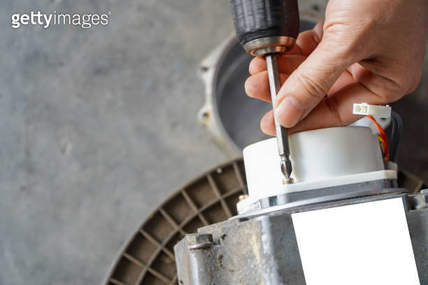 electric servo motor,Repairman using cordless screwdriver removing ...