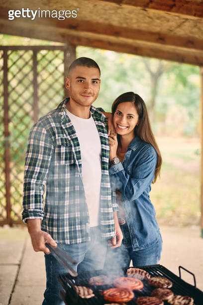 Portrait of two beautiful lovers, having a barbecue together, grilling ...