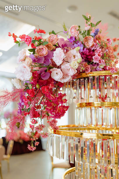 Luxurious, bright floral arrangement of roses, orchidsdecorates banquet ...