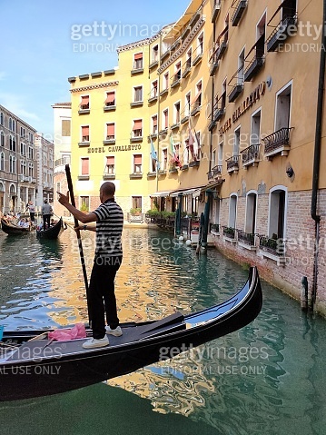 Gondolier at work in Venice with canal and old buildings 이미지 ...