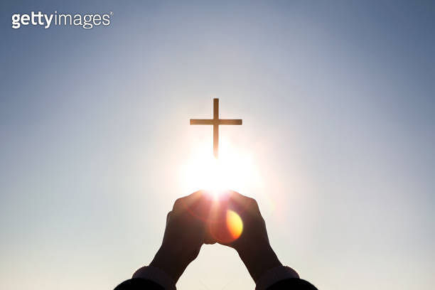 Brightly shining sunlight and silhouette of Christian hands holding ...