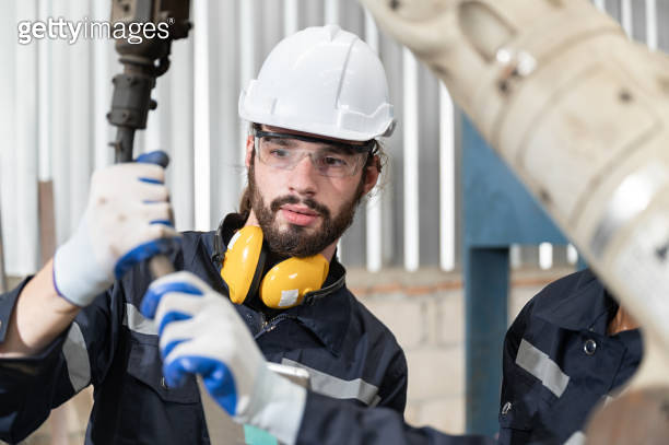 Portrait caucasian technician engineer man checking machine arm robot ...
