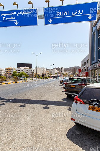 Cars and road signs on a street in the densely populated area of Ruwi ...