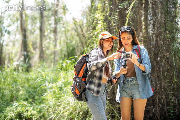 Asian two young beautiful women backpacker traveling in forest wild ...