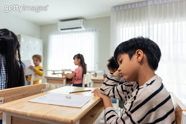 Asian young boy student doing an exam test at elementary school ...