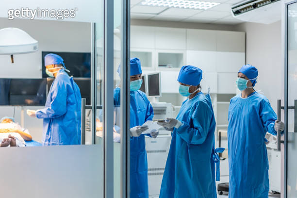 Professional doctors performing surgical operation in operating room ...