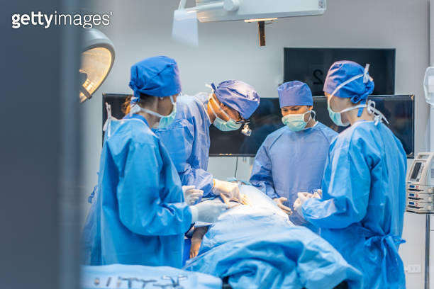 Professional doctors performing surgical operation in operating room ...