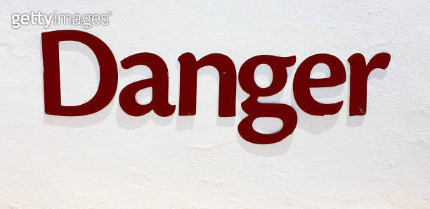 The word Danger embossed in red on a plastered wall, with discreet ...