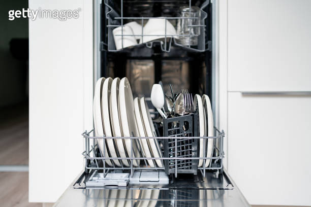 Dish washer machine. Washing plates and cutlery in basket. Open ...