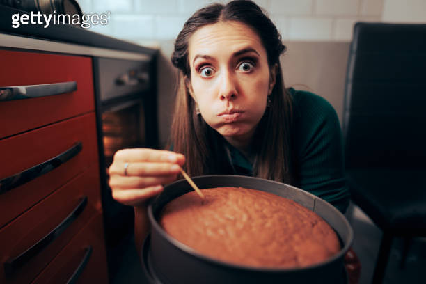 Woman Checking a Baked Cake Using a Toothpick to See if Ready ...