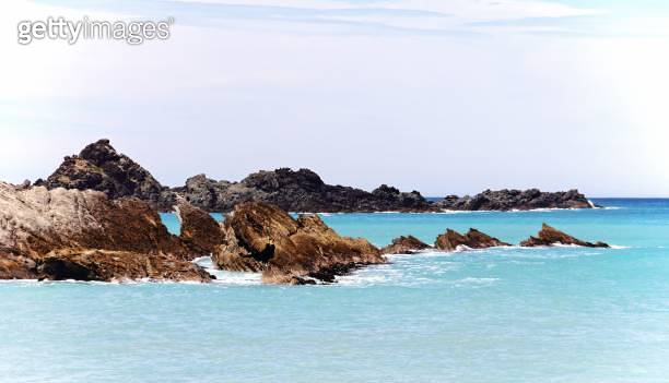 Shoreline of small rocks and crystal clear waters, Cape Palliser, New ...