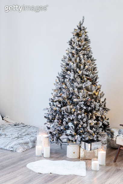 Christmas tree with presents and lights in light and airy living room ...