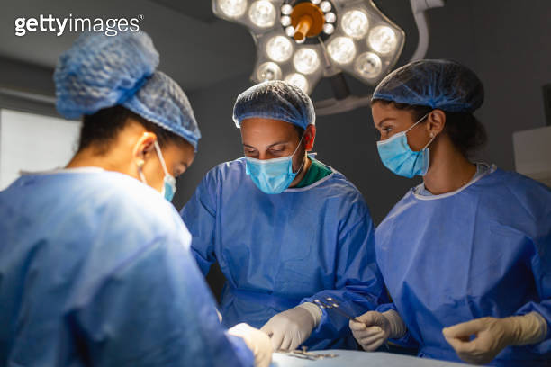 Surgical team performing surgery in modern operation theater,Team of ...