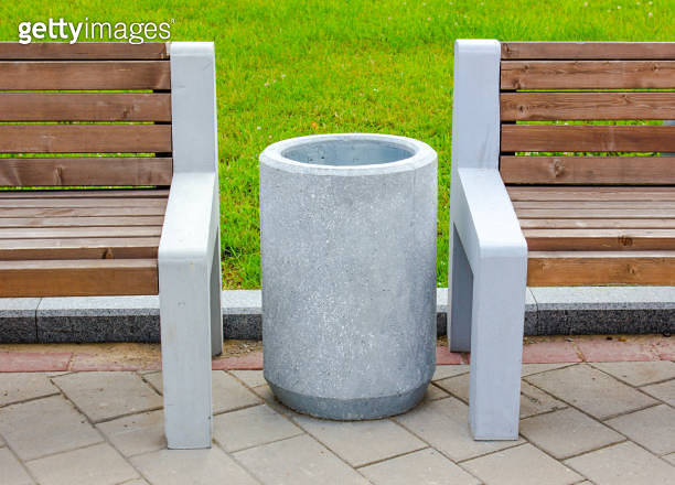 Garbage concrete, stone bin in a public park next to a bench. Garbage ...