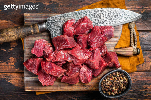 Sliced Raw venison dear meat for a stew, game meat on butcher cutting ...
