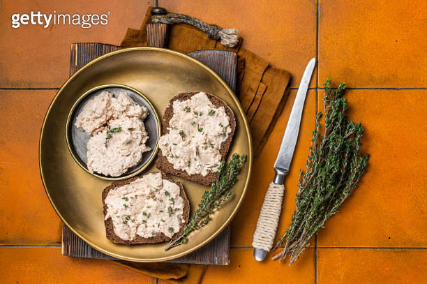 Toasts with Cod liver Spread pate on a plate. Orange background. Top ...