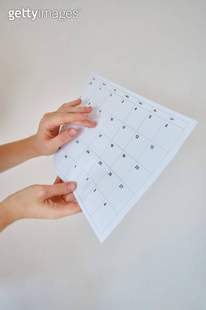 Monthly calendar in the hands of a girl. Calendar with date on paper ...