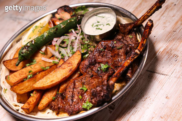 Riyash lamb chop with salad, wedges, lemon and dip served in dish ...