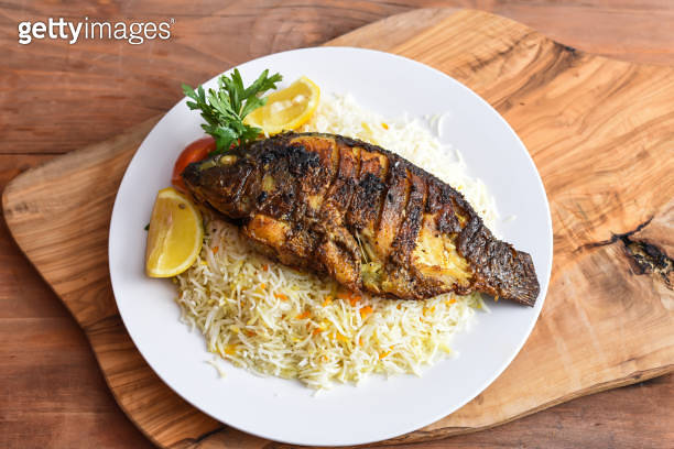 Shiri Fish fry with White Rice, tomato and lime served in dish isolated ...