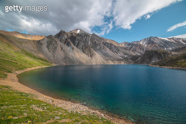 Deep mountain lake of phantom blue color among high mountains with ...