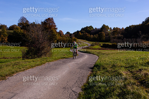 Biking cyclist male athlete going uphill on open road (1744484390) - 게티 ...