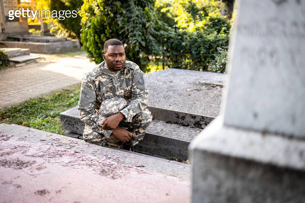 Soldier in military uniform at cemetery giving respect to his fallen ...