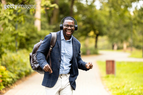 Happy man with headphones listening to music, singing and dancing while ...