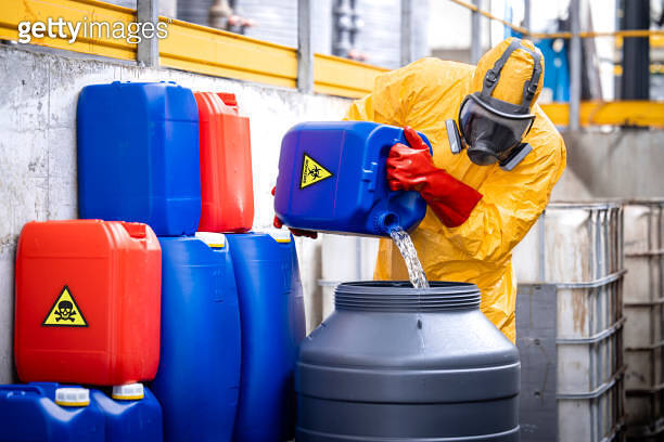Factory worker wearing yellow protection suit and gas mask working in ...