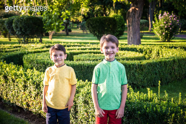 Two siblings playing at beautiful green park together. Happy family of ...