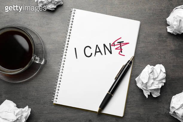 Phrase I CAN'T with crossed out letter T written in notebook, pen ...