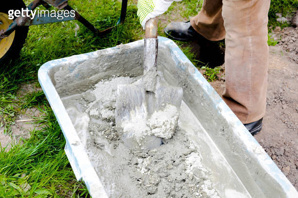 Worker man mixing, stirring cement slurry, concrete rubble mortar with ...