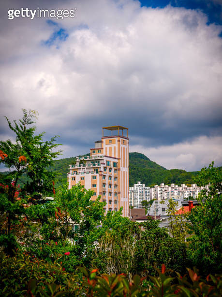 Suncheon City old town buildings, trees, mountains, and cloudscape along the Dongcheon Riverwalk ...