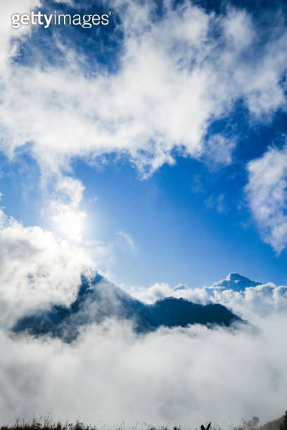 mountain summit covered by sea of cloud with blue sky in the morning ...