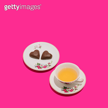 Retro romantic composition of vintage cup of tea and two chocolate ...