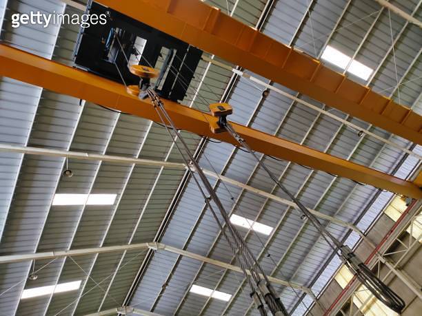 Yellow overhead crane installed on the manufacturing industry plant ...