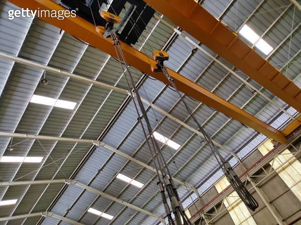 Yellow overhead crane installed on the manufacturing industry plant ...